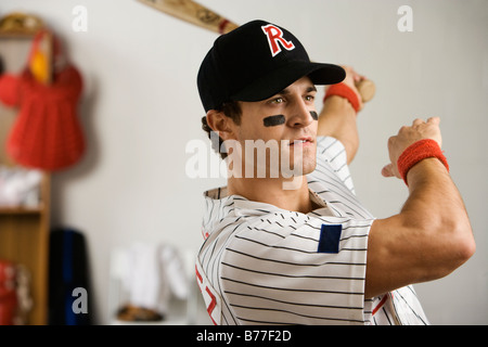 Baseball player practicing swing locker room Stock Photo - Alamy