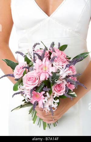 Vertical shot of a bride holding a beautiful bouquet walking on a ...