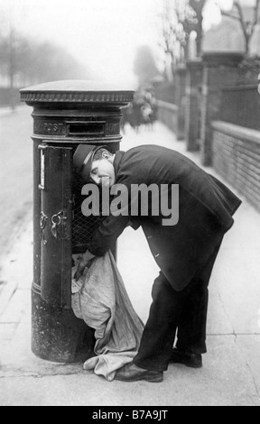 A black-and-white photograph of a letter carrier delivering mail by ...