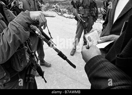 A Palestinian man shows his identification card to Israeli soldiers in ...