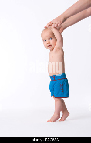 Toddler taking first steps in a park Stock Photo - Alamy