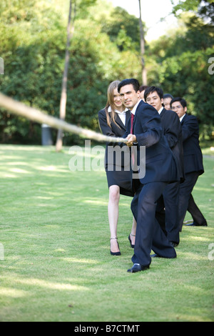 Young business man pulling a tightrope for businesswoman against ...