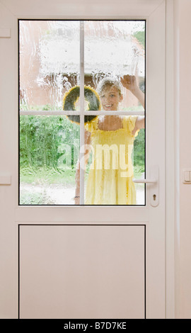 young girl knocking on front door of house using metal door knocker ...