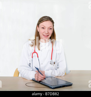 Female doctor using tablet computer while sitting at the workplace ...
