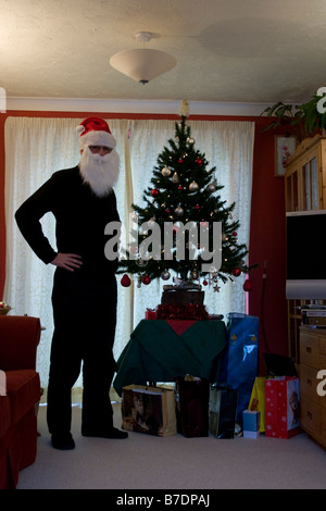 A man in a Santa hat stands by a camera tripod Stock Photo - Alamy
