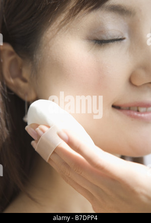 Woman applying powder with puff Stock Photo - Alamy