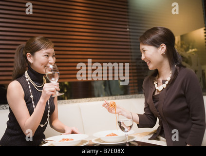 Two women drink water and wine @ wine waiter pours wine @ serve ...