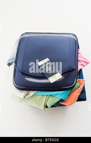 Clothes stuffed in a suitcase Stock Photo - Alamy