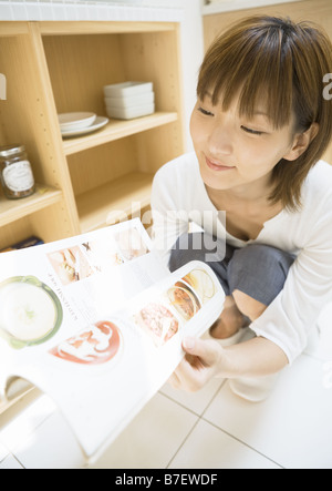 Woman reading cooking book Stock Photo - Alamy
