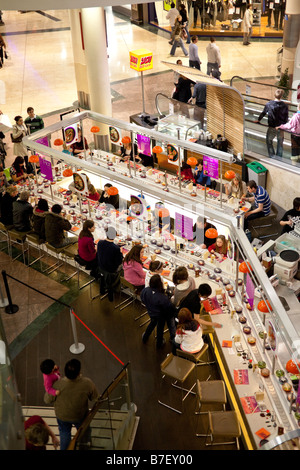 People & YO Sushi restaurant business food in bowls on a rotating ...