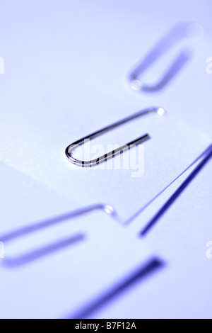 Paperclip on paper in pile close up Stock Photo - Alamy
