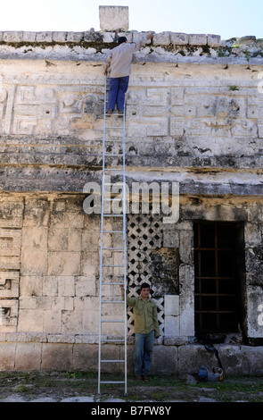 Worker on ladder restoring facade of Annex in old Chichen Itza, Mexico ...