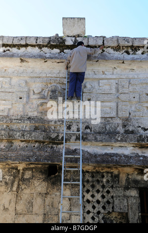 Worker on ladder restoring facade of Annex in old Chichen Itza, Mexico ...