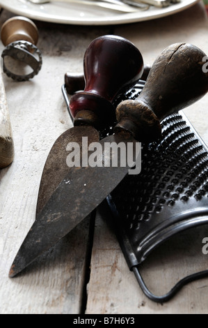 selection of old or antique cooking utensils hanging on a rack in a ...