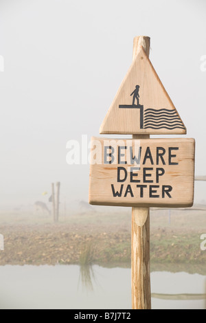 Wooden sign warning of danger near cliff on the Cape to Cape trail ...