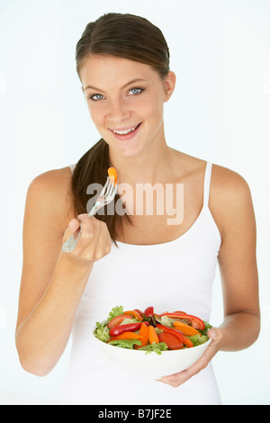 Beautiful young happy woman with fresh broccoli on beige background ...