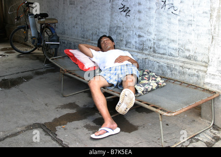 Sleeping Chinese on a street of Shanghai. People take a nap anywhere ...