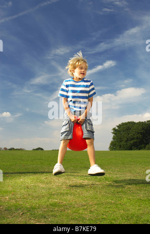 Young boy bouncing on a Space Hopper Stock Photo - Alamy