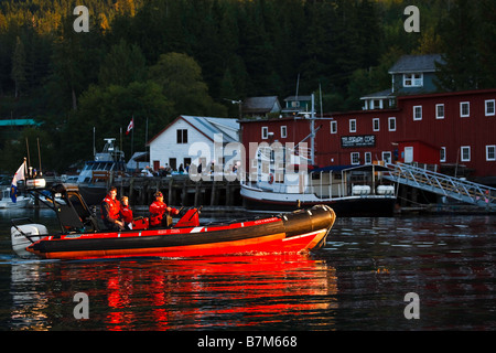 Zodiac with people is traveling in front of huge iceber Stock Photo - Alamy