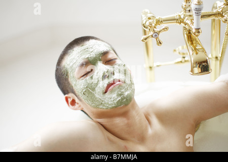 Man Relaxing in a Bathtub with a Facial Mask Stock Photo - Alamy
