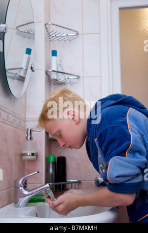 Young teenage boy washing his face with a flannel Stock Photo - Alamy