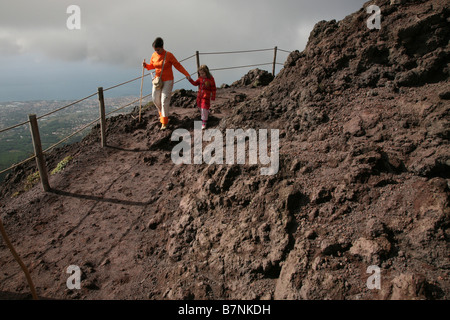 Tourists walk by the rim of the crater of Mount Vesuvius in Campania ...