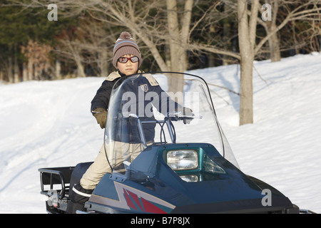 A boy riding on snowmobile Stock Photo - Alamy