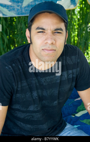 Portrait of a relaxed, confident young hispanic man, joyfully enjoying ...