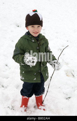 Happy boy playing with snow in winter Stock Photo - Alamy