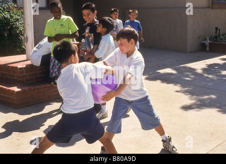 Boys fight over ball on playground Stock Photo - Alamy
