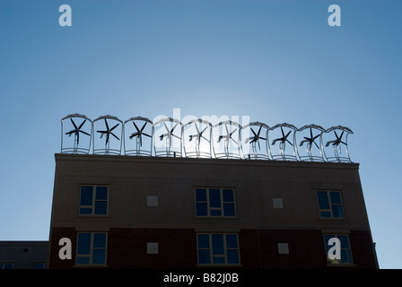 Wind turbines are seen on the roof of an apartment building under ...