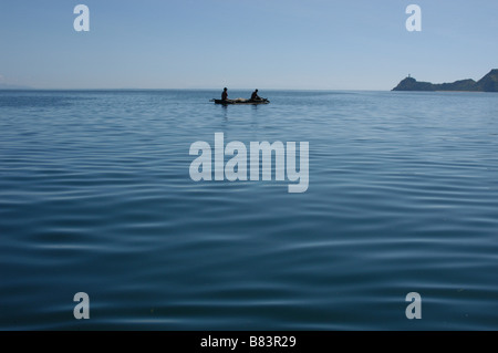 An outrigger canoe in Dili harbor Timor Leste and an inter-island ferry ...