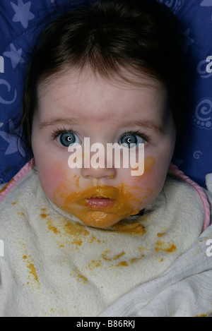 Baby girl with baby food around mouth Stock Photo - Alamy