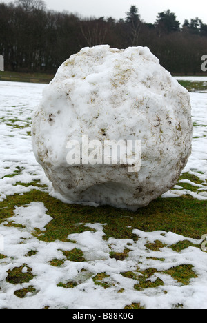 Giant rolled snowball in a park with hole in middle Stock Photo - Alamy