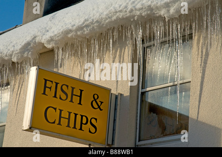 Rooftop Icicles hang above a Fish and Chip sign in the Scottish ...