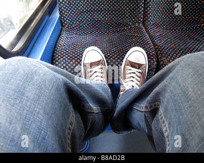 Feet resting on bus seat Stock Photo - Alamy