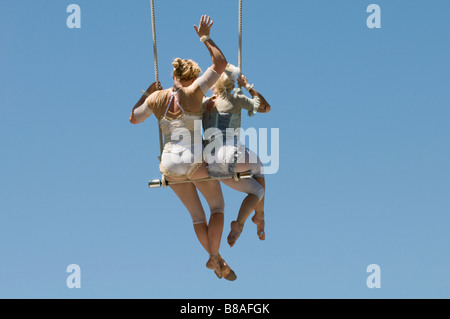 Two female trapeze artists on swing Stock Photo - Alamy