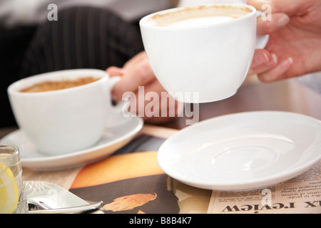Two hand Holding Coffee Cup on wooden table Stock Photo - Alamy