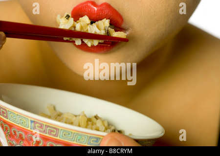 Asian woman eating rice with chopsticks over white background Stock ...