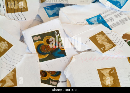 pile of used British postage stamps torn off envelopes and postcards ...