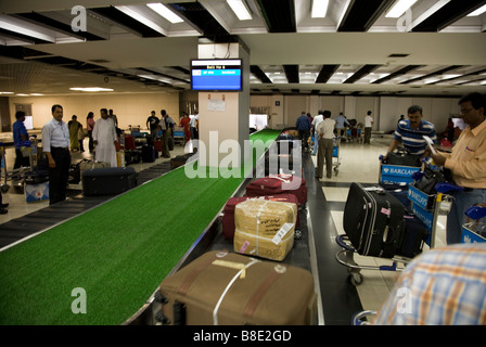 Air passengers collecting their luggage in the baggage hall, terminal ...