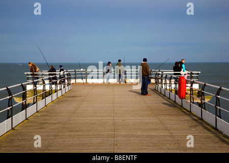 Anglers fishing from the end of Saltburn Pier at high tide on a warm ...