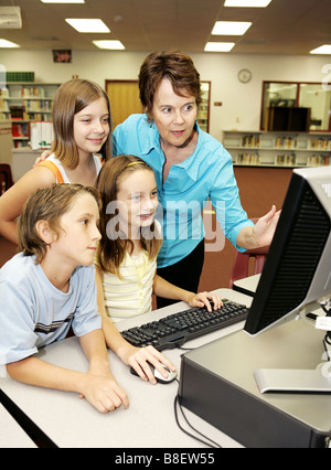 Teacher instructing student using computer in class at school Stock ...