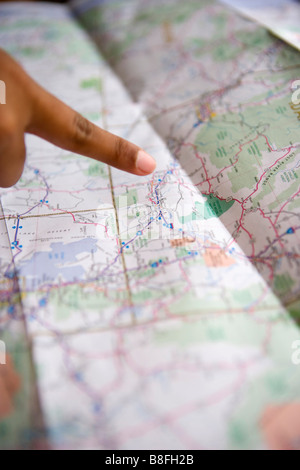 Close-up of a persons hand pointing out their location on a map at a ...