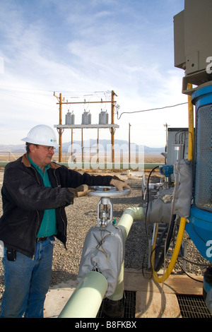 Operator turning a valve at a geothermal power plant in Malta Idaho USA ...
