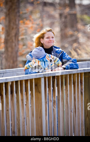 Thoughtful mother carrying baby on woodland walk Stock Photo - Alamy