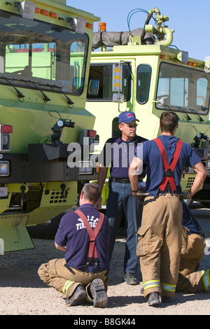 Firefighters taking direction from a training officer at an airport ...