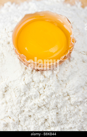 open egg on a bed of flour Stock Photo - Alamy