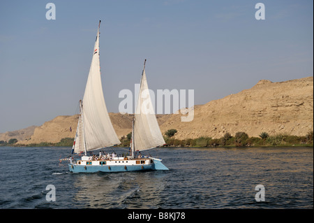 A dahabiya sailing on the river Nile Egypt, near the bank with palms ...