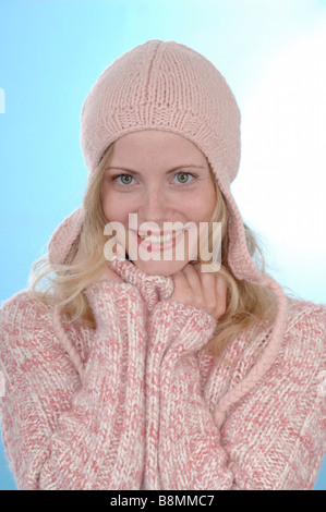 A stylish blonde woman models a chic denim ensemble against a warm ...